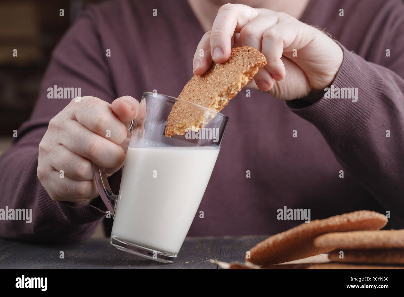 Sesame cookies, male dunking cookies in milk Stock Photo - Alamy
