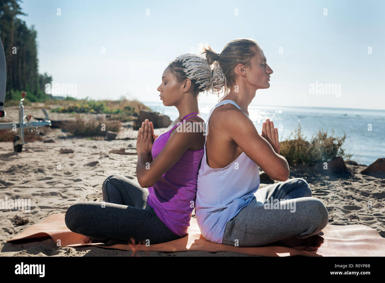 Healthy loving couple breathing slowly while meditating together in ...