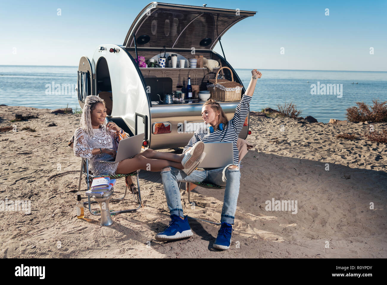 Couple living in mobile home working remotely sitting on chairs Stock ...