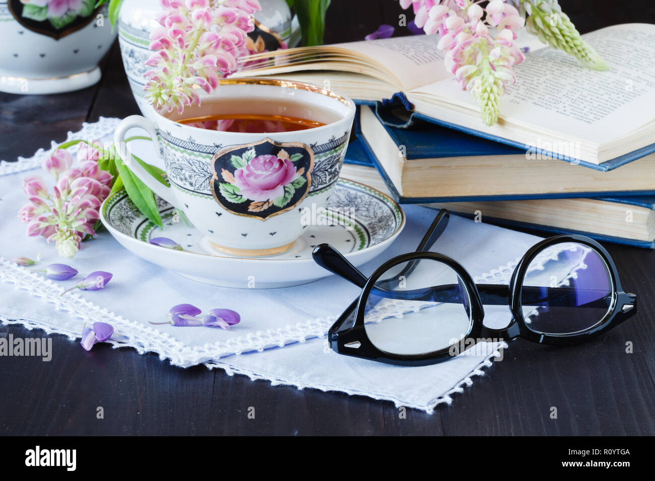 Cup of tea with books and flowers on wooden background Stock Photo - Alamy