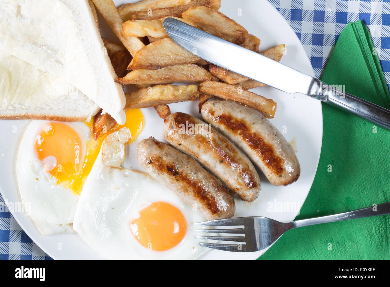 Classic British supper of Sausage, egg and chips with white sliced ...