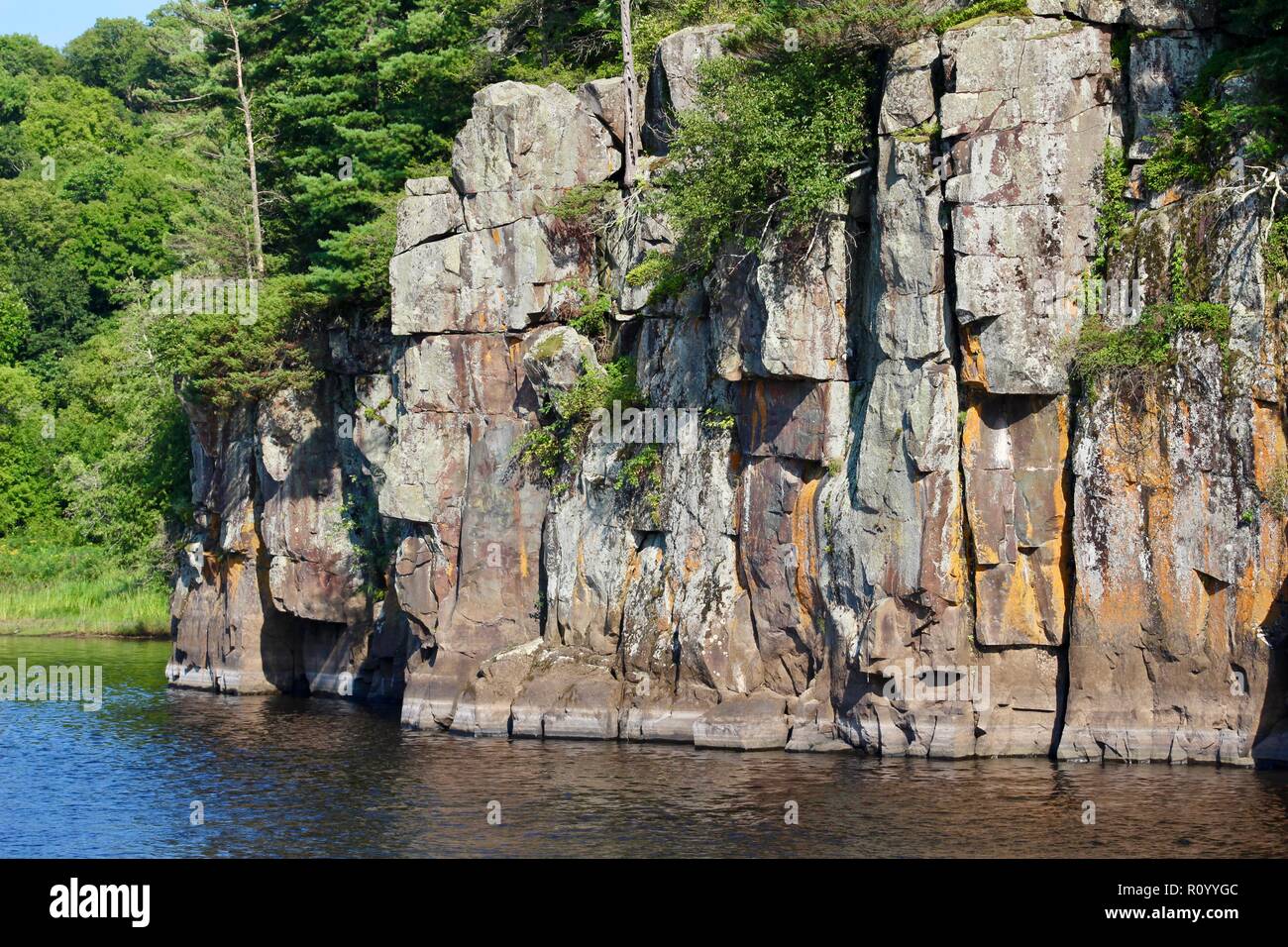 Large scenic river with beautiful glacier-carved rocky cliff formations ...