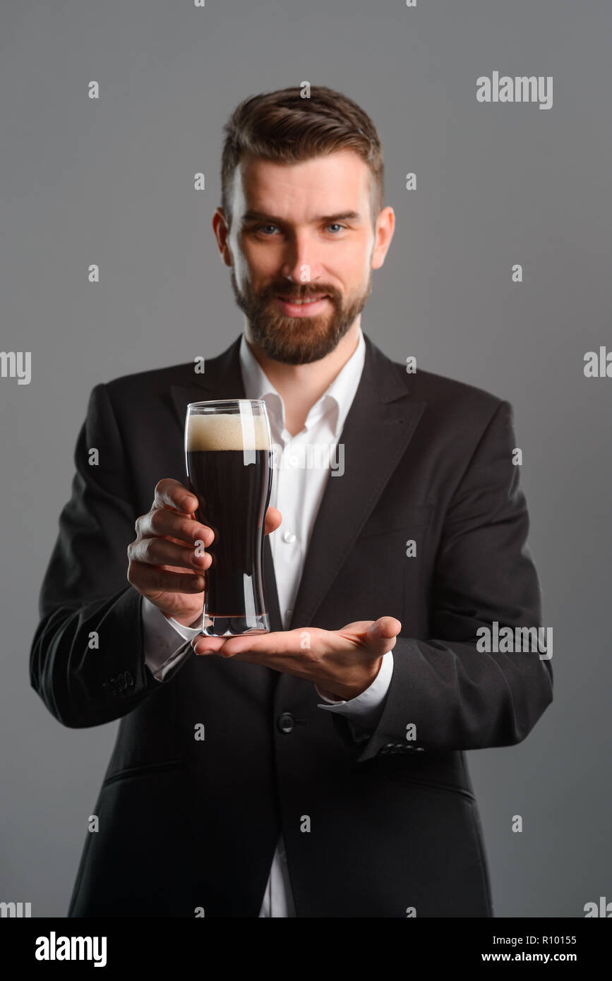 Young man showing beer glass Stock Photo - Alamy