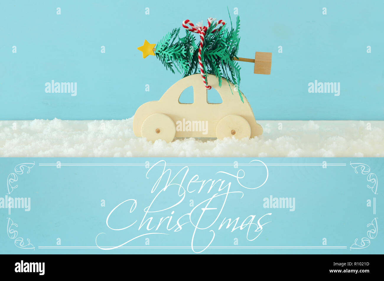 Wooden car carrying a christmas tree in front of blue background Stock ...