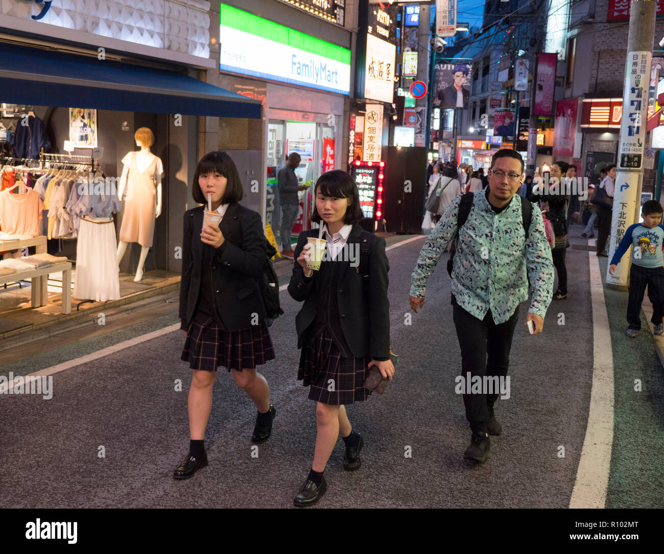 School girls walk the narrow streets of Shimo-Kitzawa in Tokyo, Japan ...