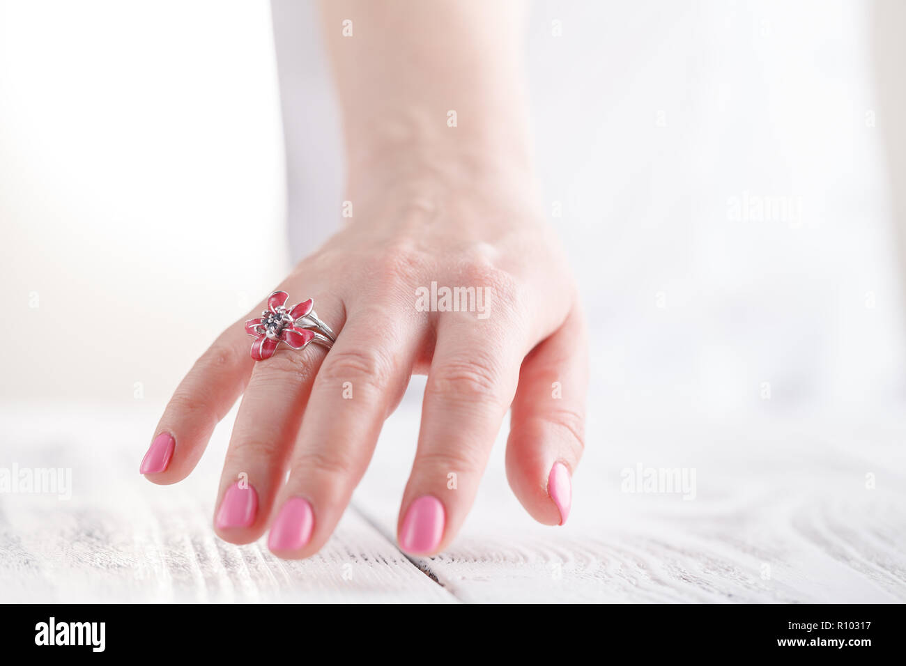 Female hands with ring on finger lay on whie table Stock Photo - Alamy