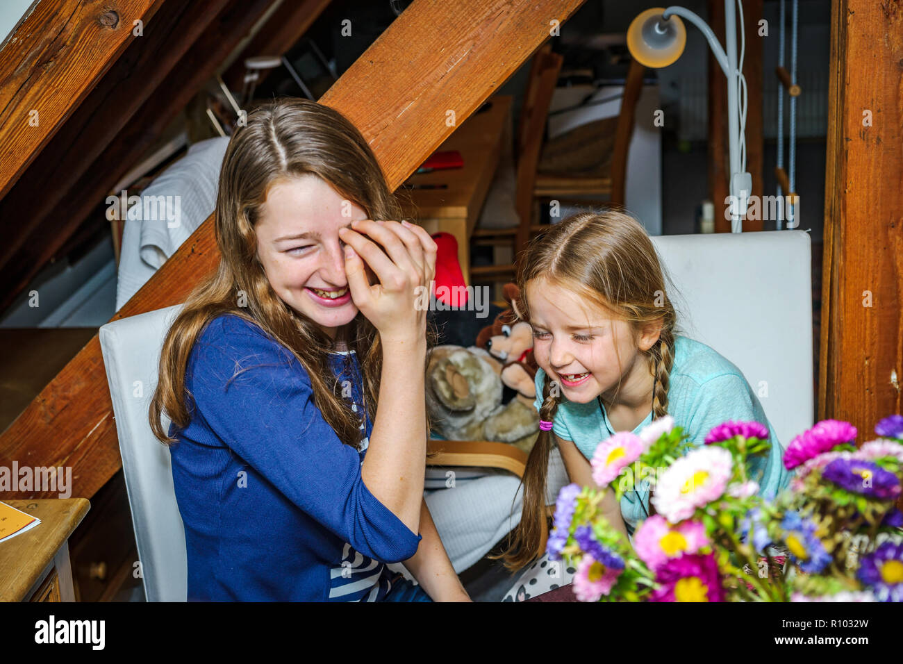 Two sisters are happy together,speaking and smiling, indoor Stock Photo ...