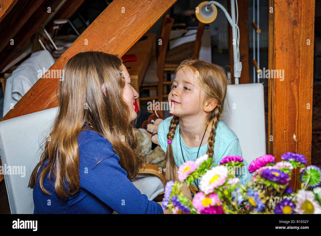 Two sisters are happy together,speaking and smiling, indoor Stock Photo ...