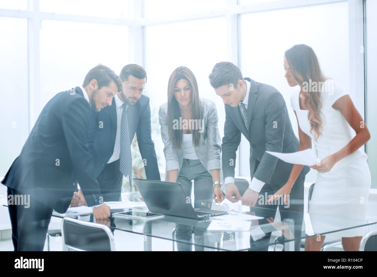 group of employees looking at the laptop screen Stock Photo - Alamy