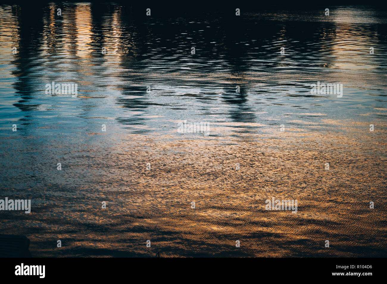 Water surface with glare of sunset sun and reflections. Texture sea ...
