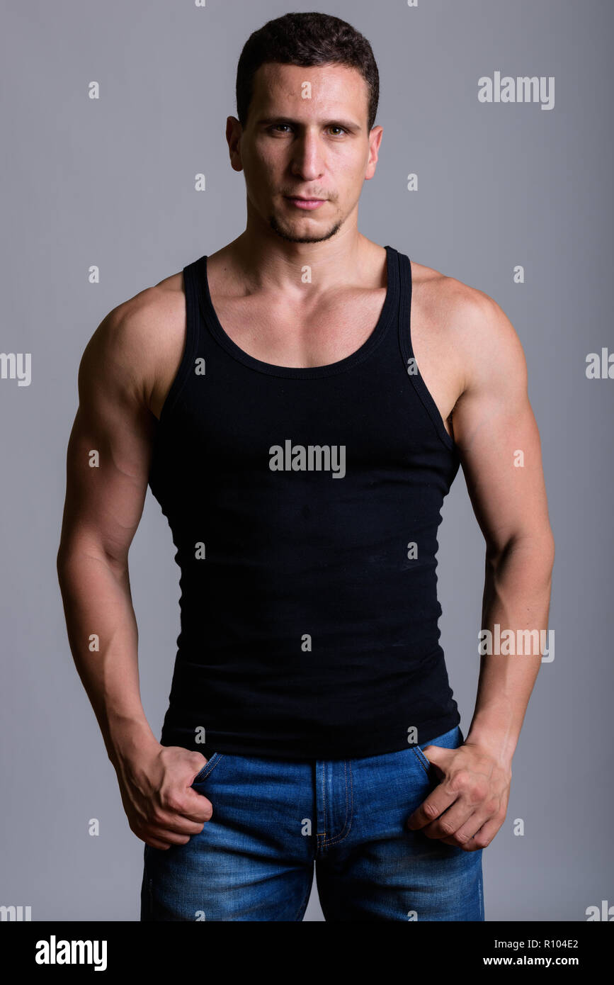 Studio shot of young muscular Persian man standing with hands on Stock ...