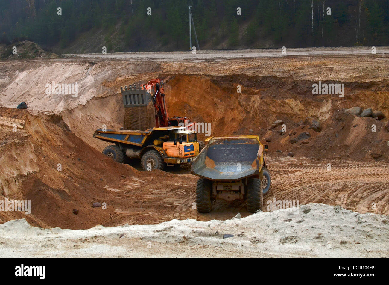 Large quarry dump truck. View of the large sand pit. Production useful ...