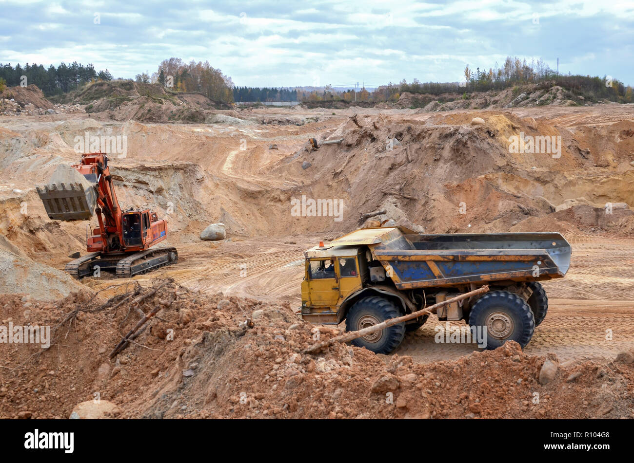 Excavator loading sand into dumper truck. Large quarry dump truck. View ...