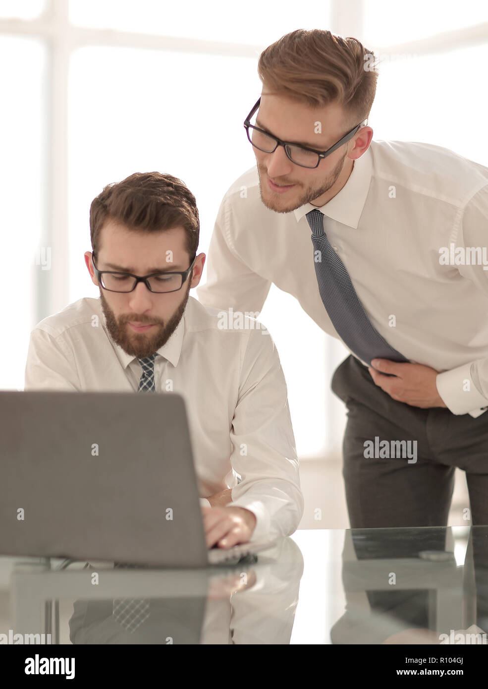 two employees using a laptop in the workplace in the office Stock Photo ...