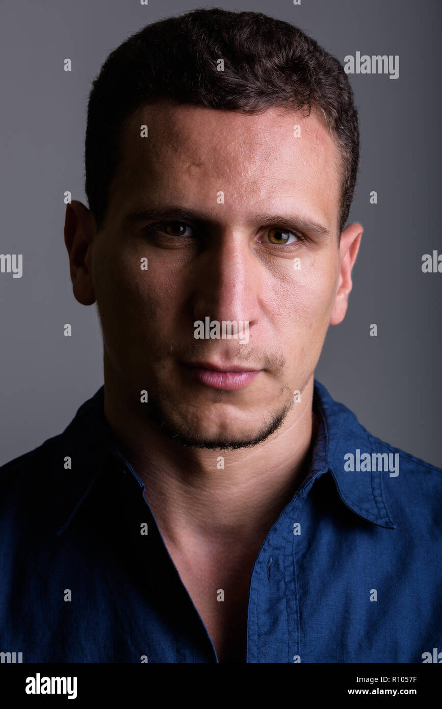 Face of young muscular Persian man against gray background Stock Photo ...