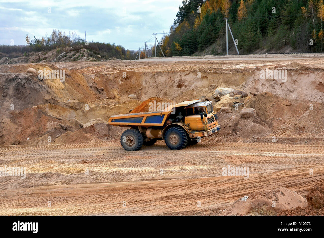 Earth mover loading dumper truck with sand in quarry. Excavator loading ...