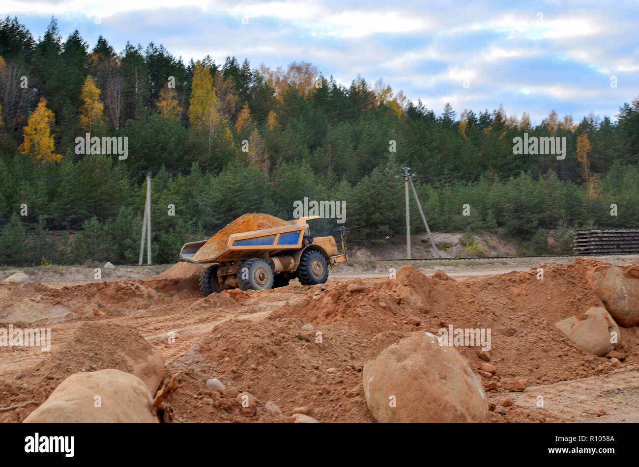 Earth mover loading dumper truck with sand in quarry. Excavator loading ...