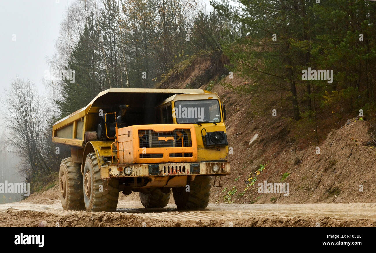 Earth mover loading dumper truck with sand in quarry. Excavator loading ...