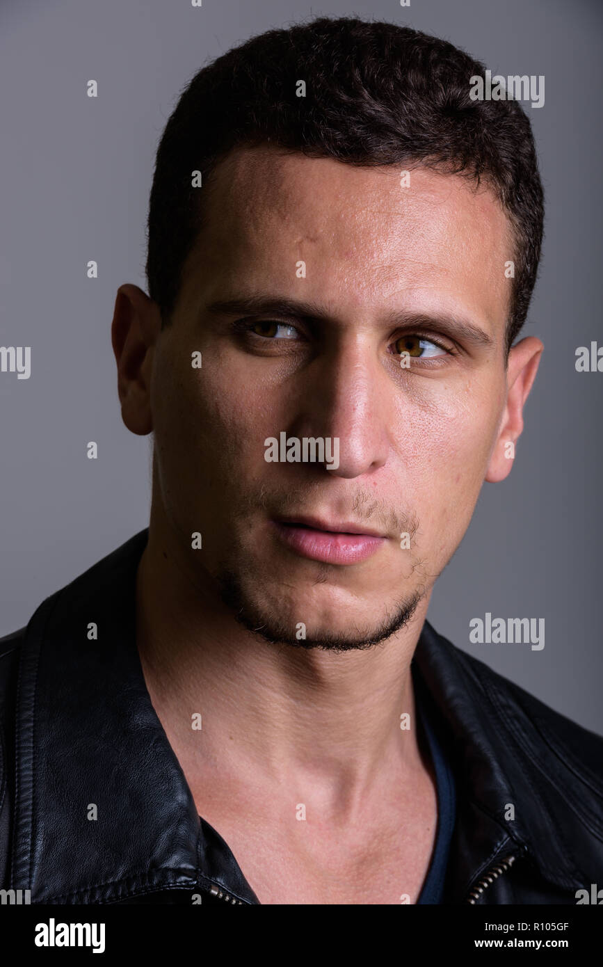 Face of young muscular Persian man thinking while looking suspic Stock ...