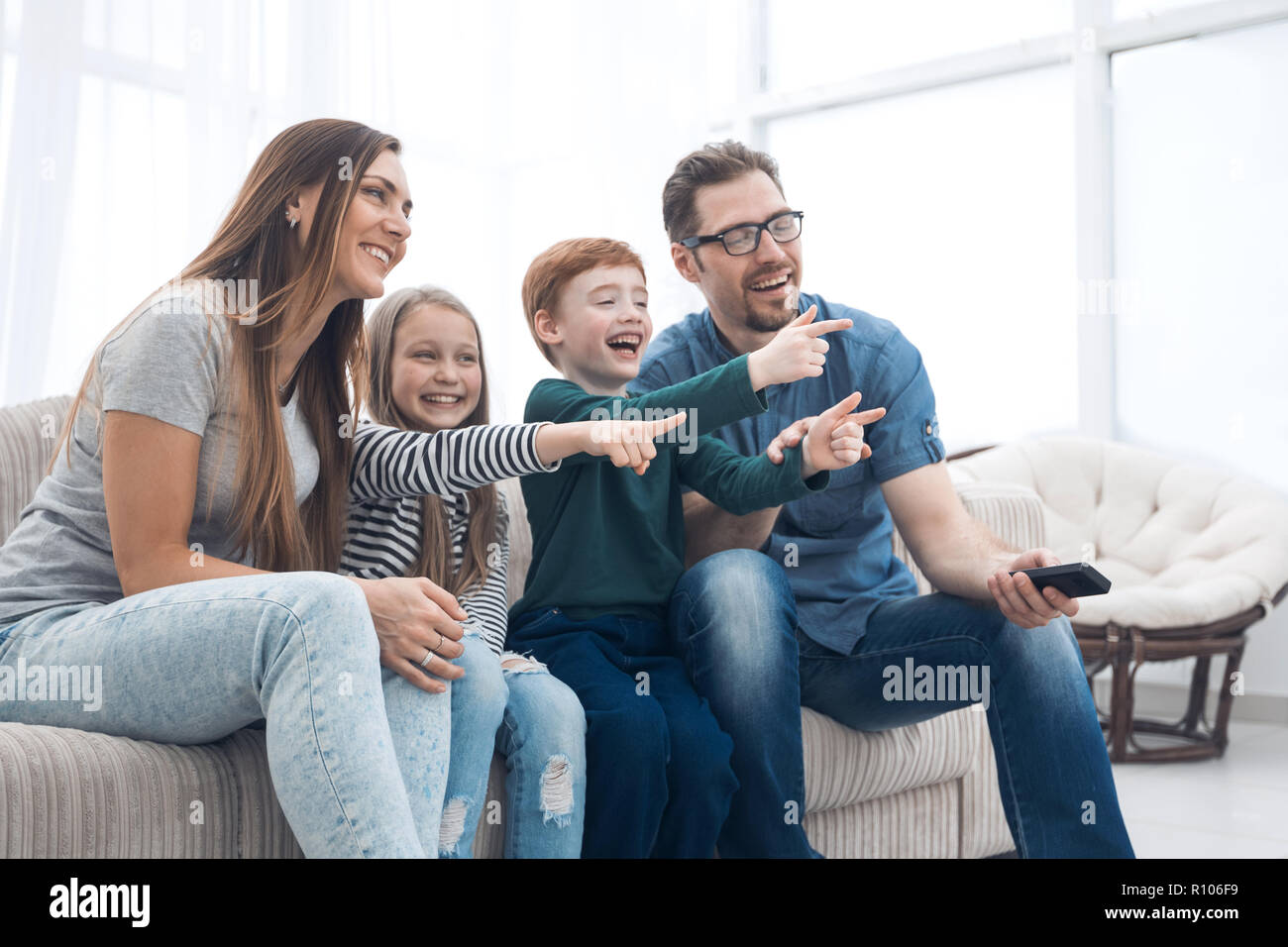 happy family sitting watching TV in their home Stock Photo - Alamy