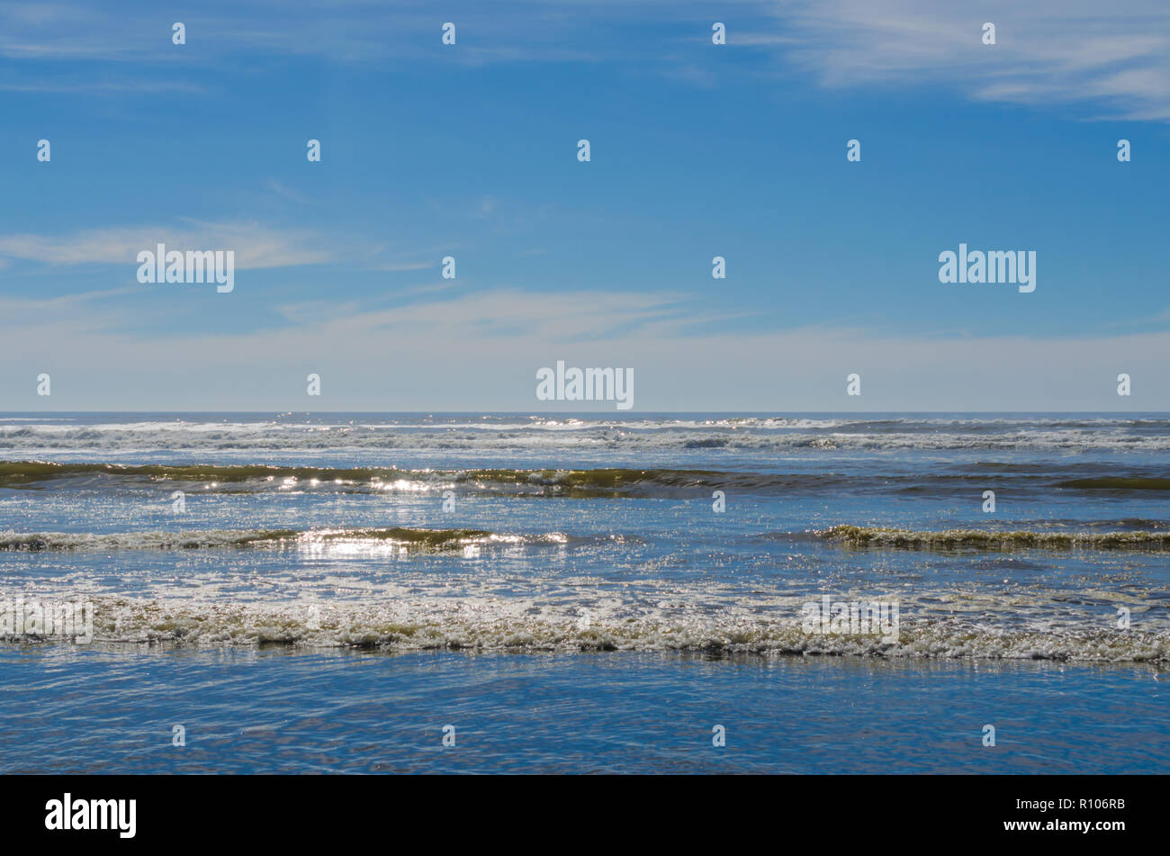 Ocean beach scene, sparkling waves splashing onto seaside shoreline ...