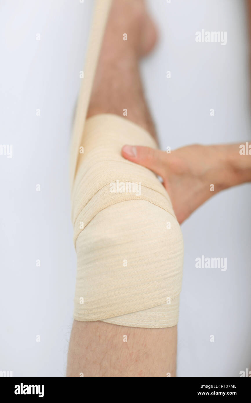 closeup. doctor bandaging a patient's leg Stock Photo - Alamy