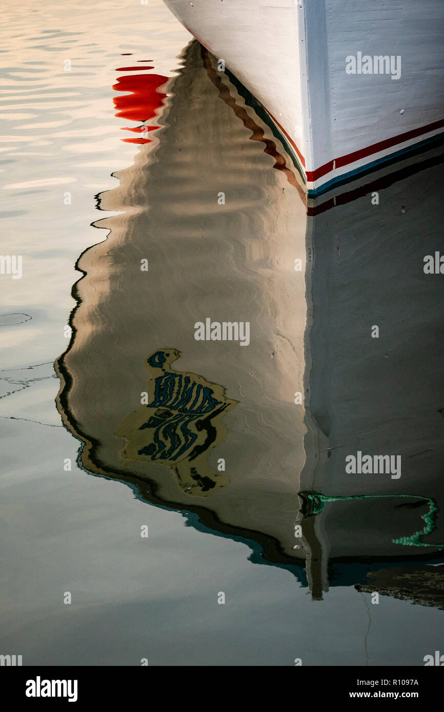 Fishing boat hull reflected on calm water Stock Photo - Alamy