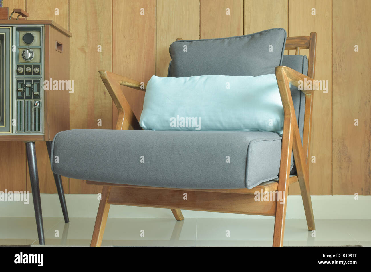 Easy lounge chair with wooden wall background in retro style decoration ...