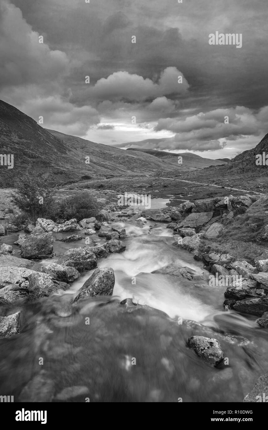 Black and white Landscape image of river flowing down mountain range ...