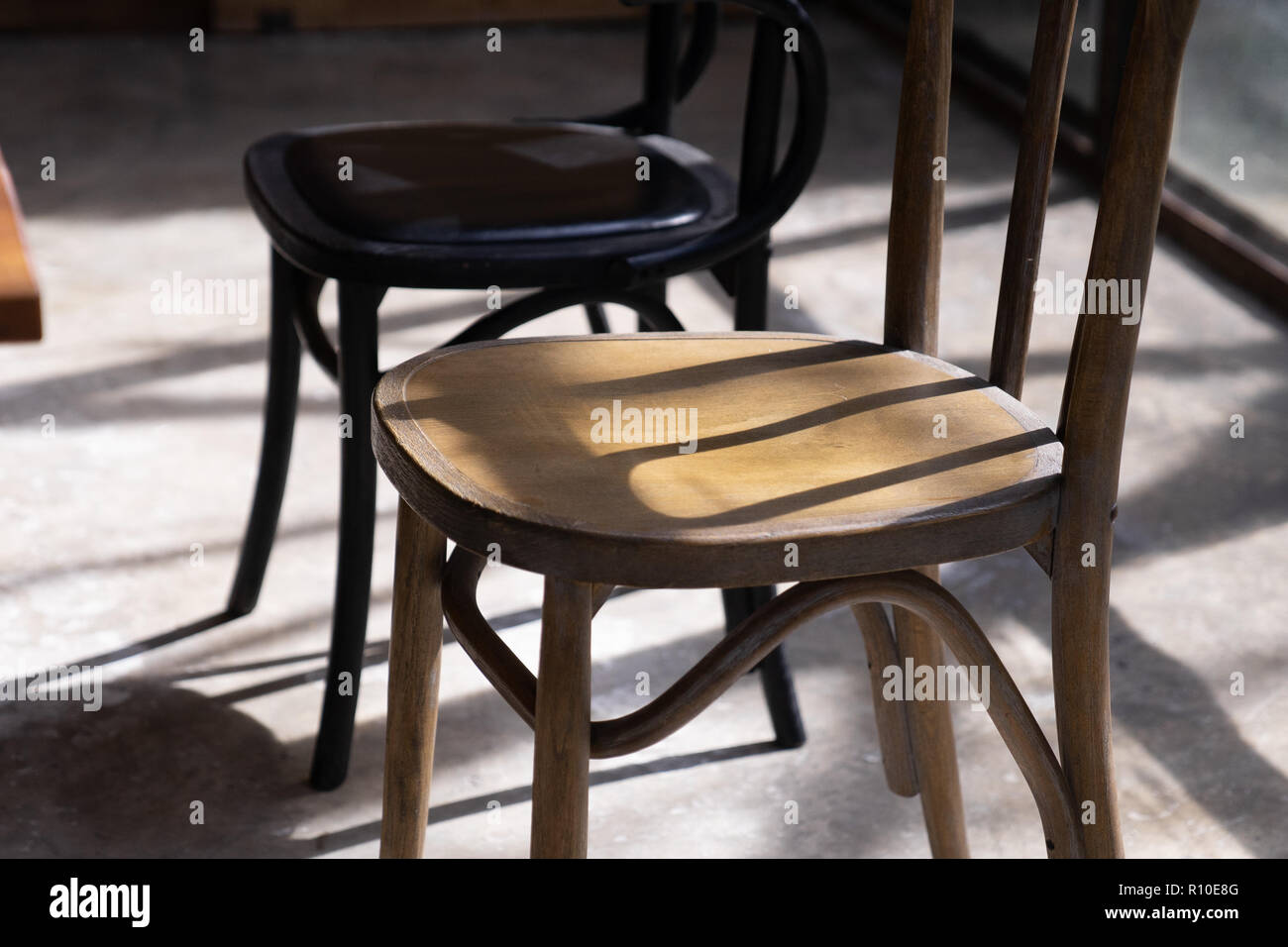 close up wooden chair seat with shadow and light on grunge cement ...