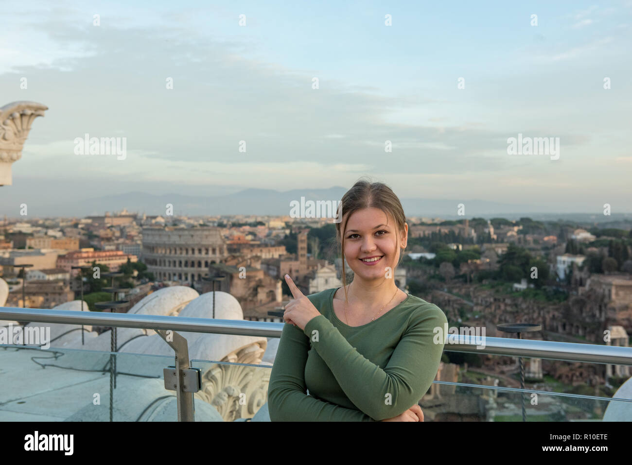 young woman wearing green pullover on the roof in front of Colosseum ...