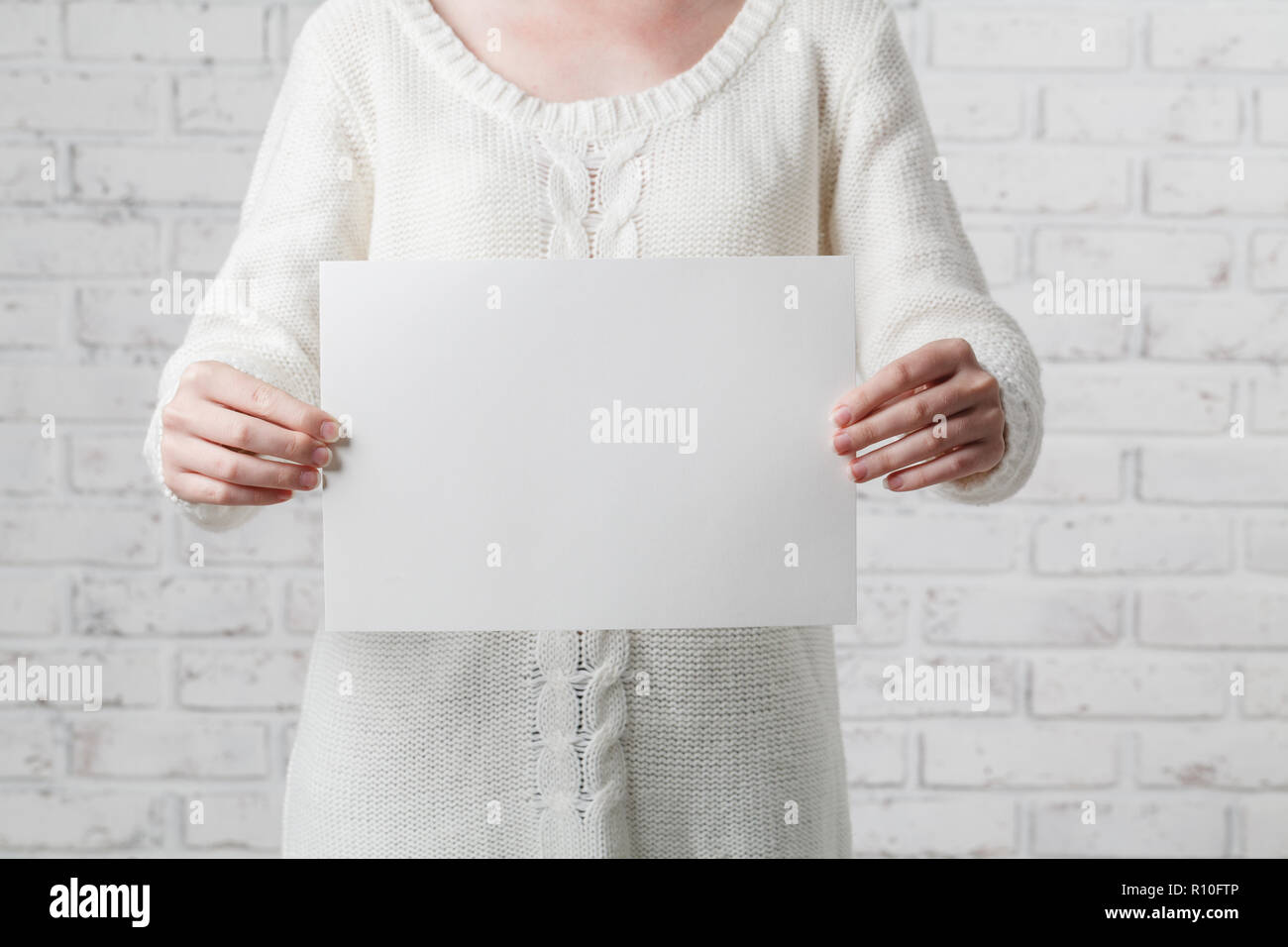 Handing a blank business a4 card over in hand Stock Photo - Alamy