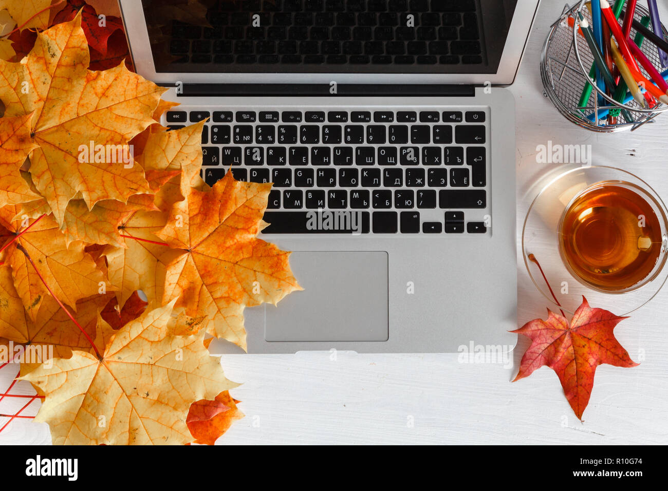 Girly office desktop with blank white laptop screen, flowers, coffee ...