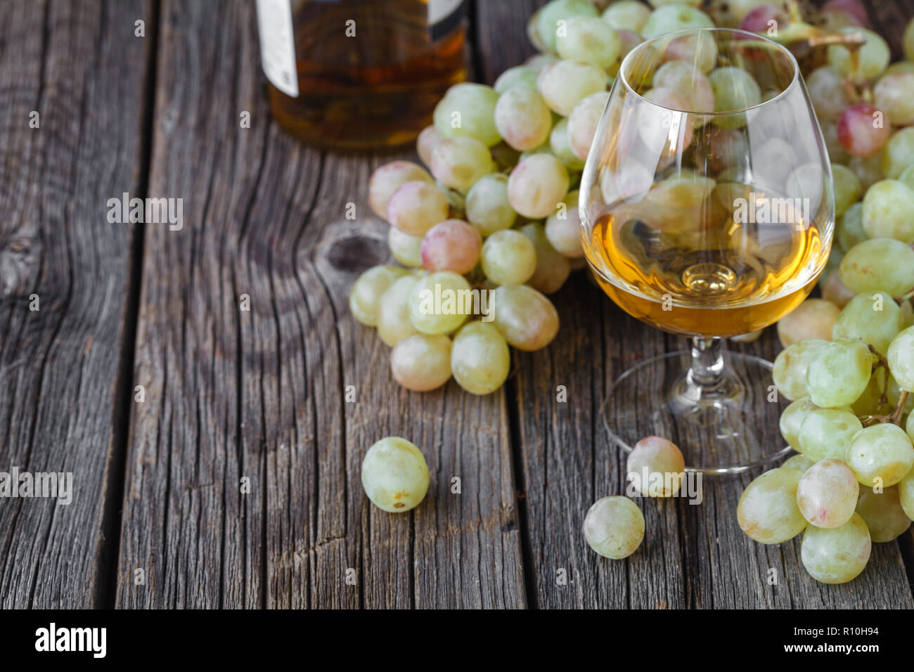 Glass of brandy with brush of grapes on table, harvest holiday Stock ...