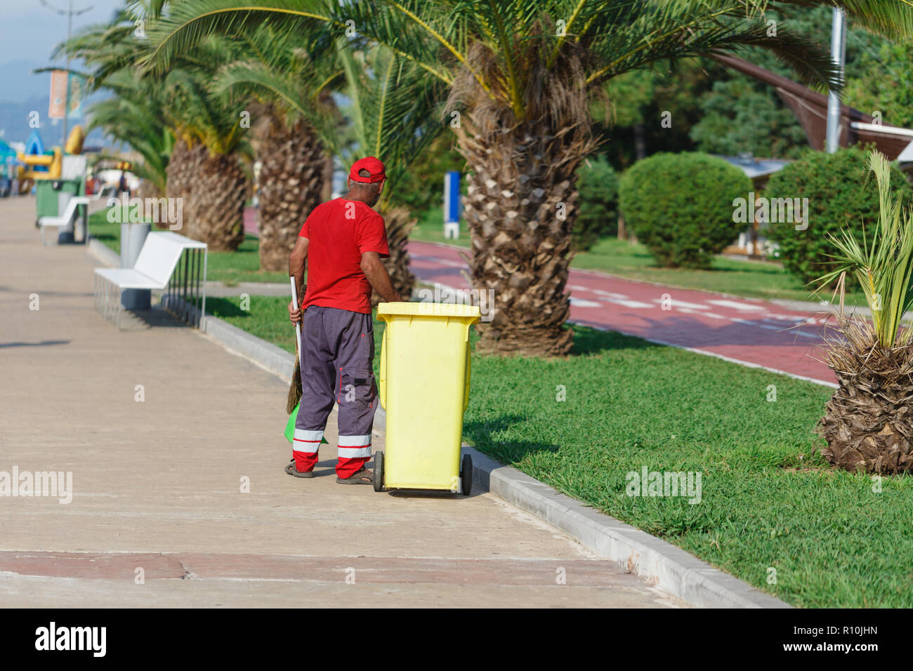 Worker of cleaning company in uniform with a garbage bin Stock Photo ...