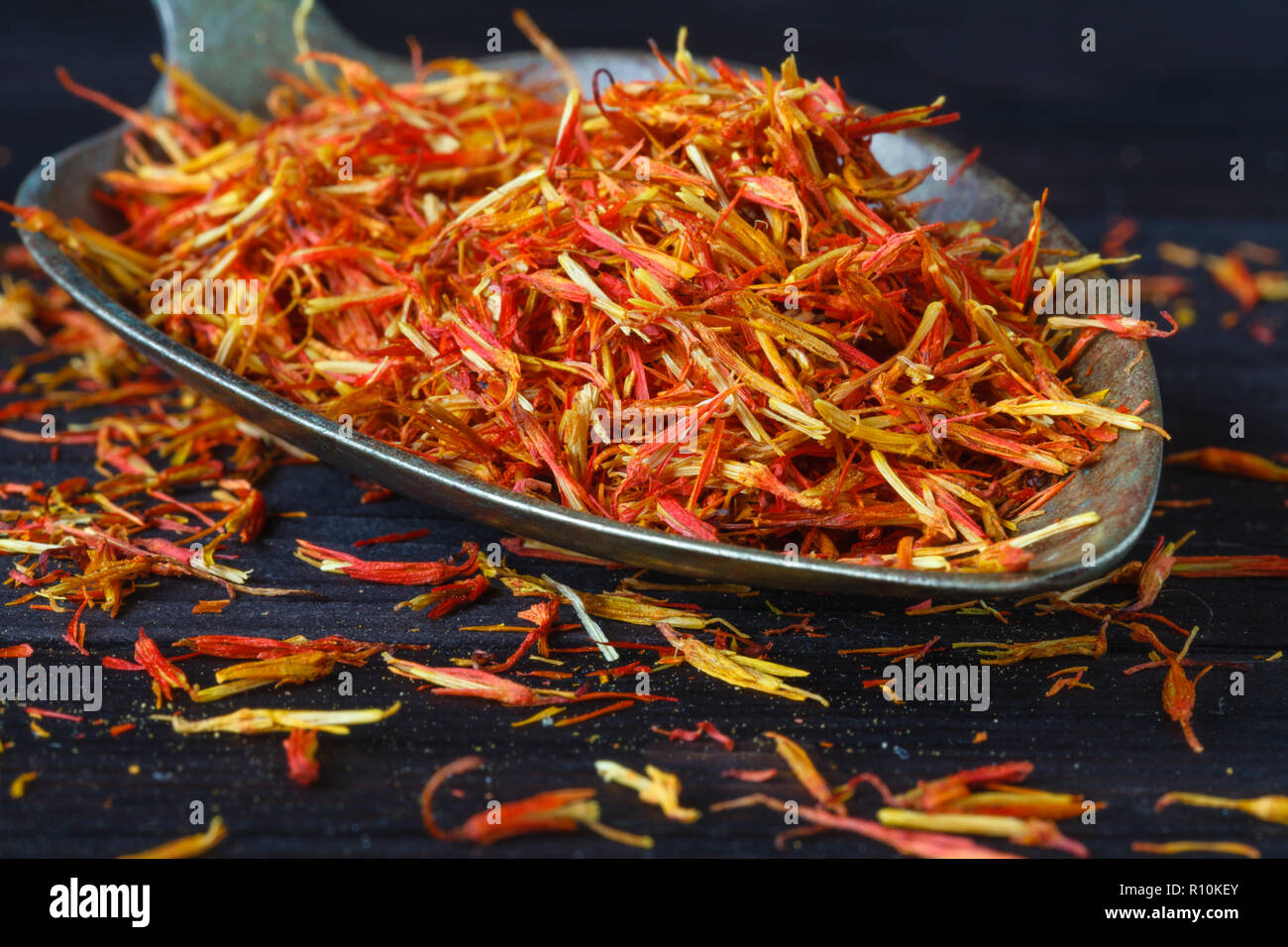 Saffron spice in spoon on wooden background Stock Photo - Alamy
