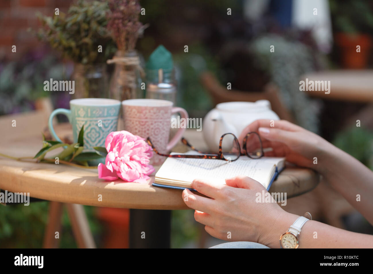 Female with a book outdoors cafe Stock Photo - Alamy