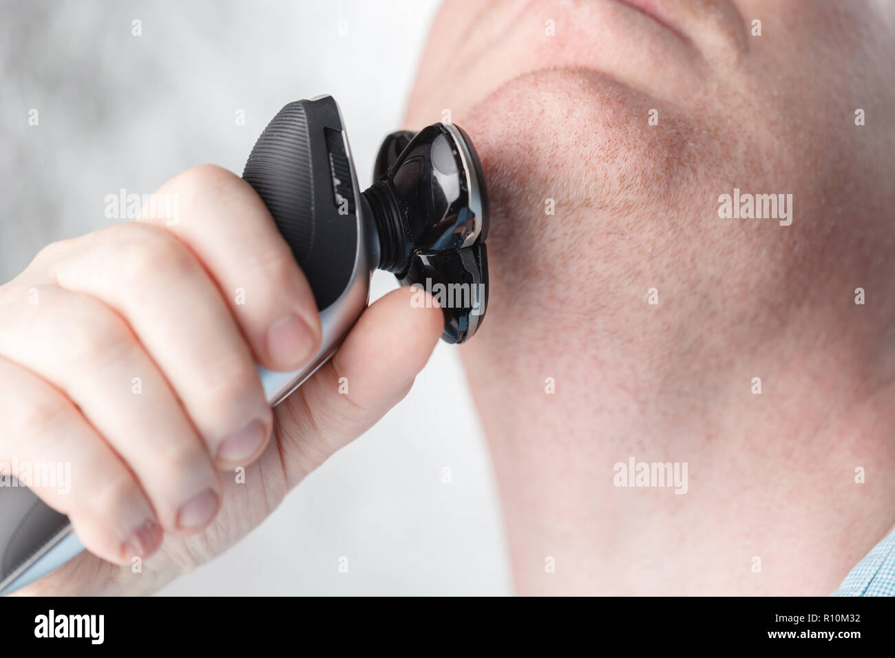 Man shaving with electric razor Stock Photo - Alamy