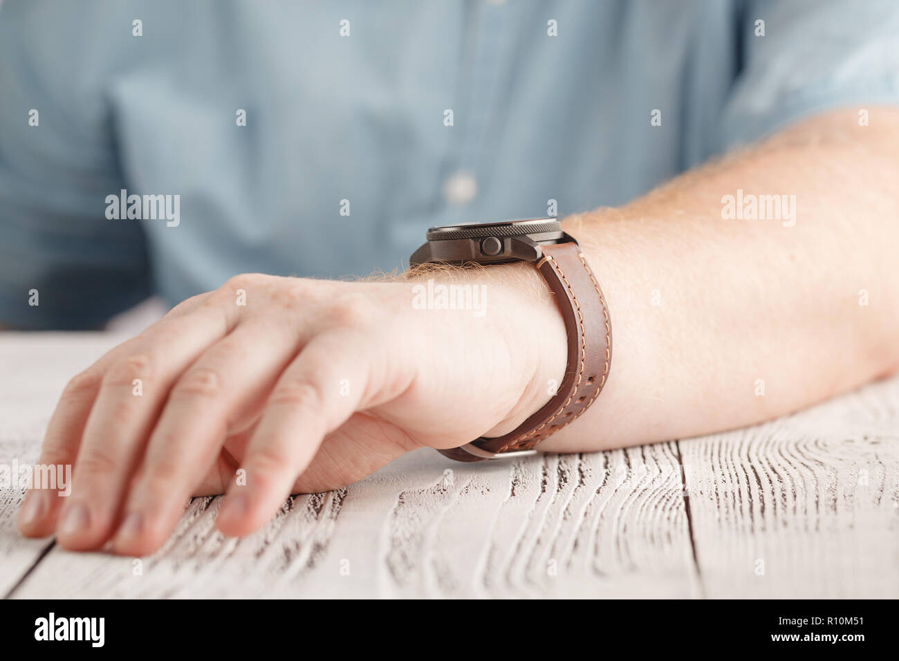 men wearing a black watch with black leather strap over a white ...