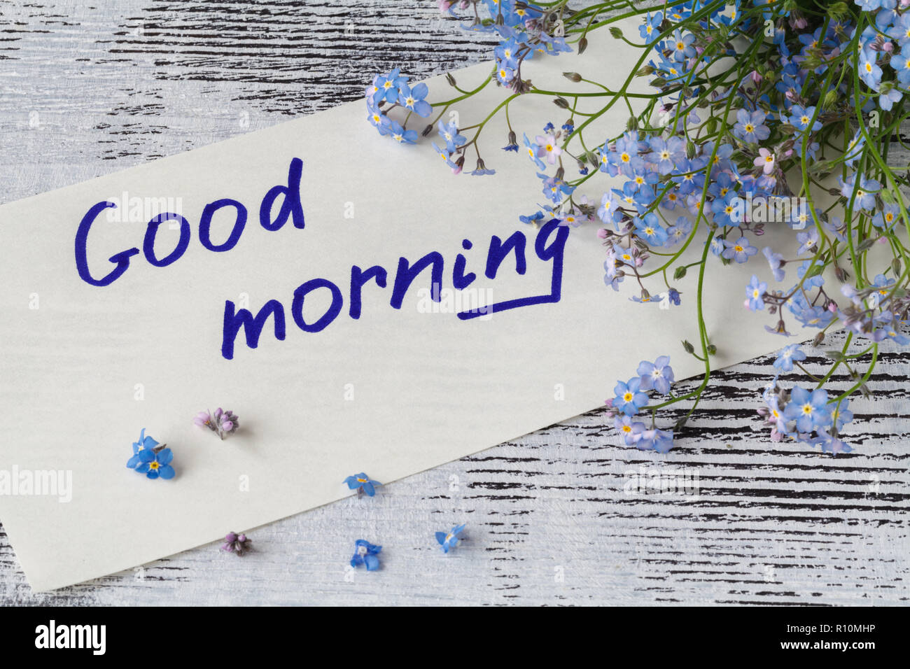 Good morning note and forget me not flower on the wooden table Stock ...