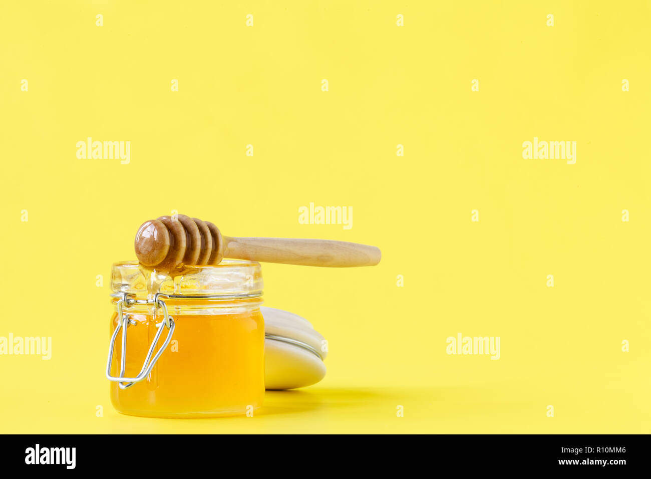 Honey dropping from dipper into a jar Stock Photo - Alamy