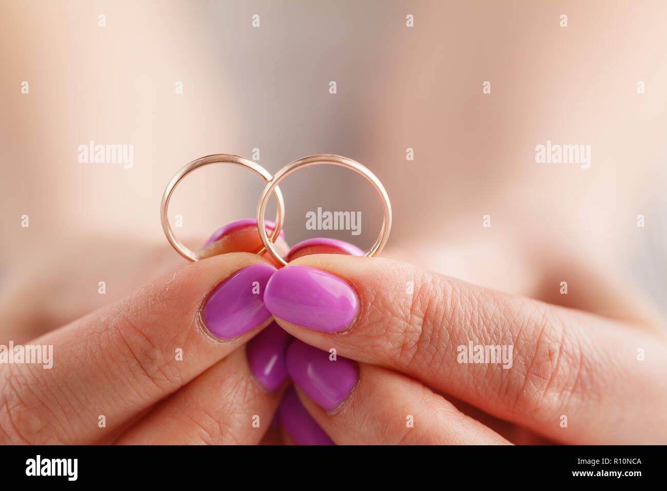 Two hands holding two gold rings wedding Stock Photo - Alamy