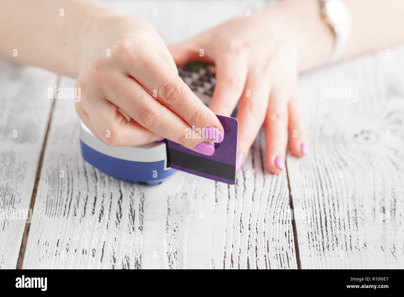 Hand swiping debit card on pos terminal Stock Photo - Alamy