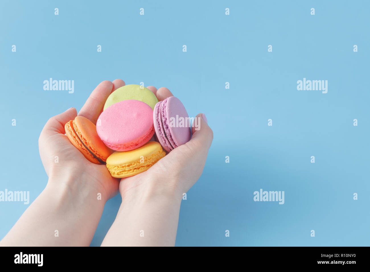 Girl holding colorful French macarons in hands Stock Photo - Alamy