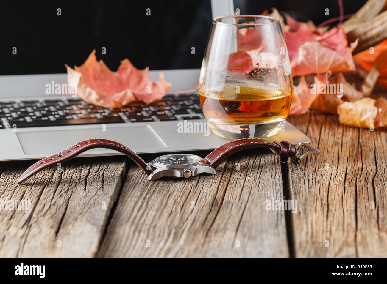 glass with whiskey on wooden table with laptop Stock Photo - Alamy