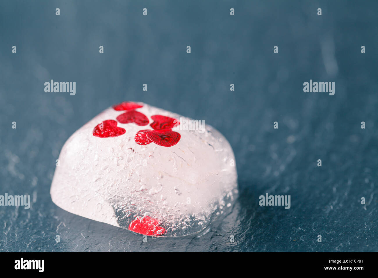 frozen red heart as a symbol of frozen love, ice cubes with heart, a ...