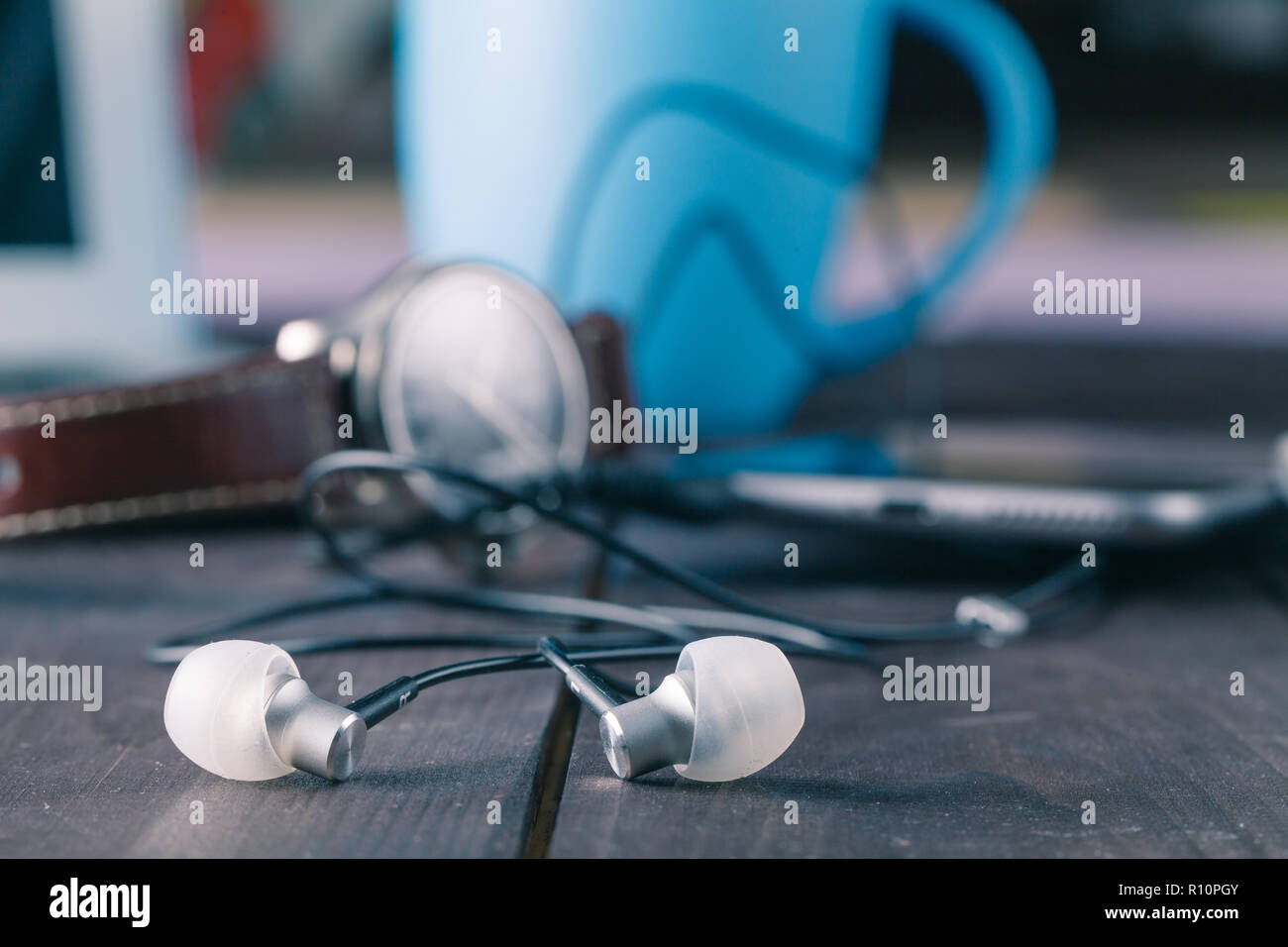 headphones on wooden table with phone and mug Stock Photo - Alamy