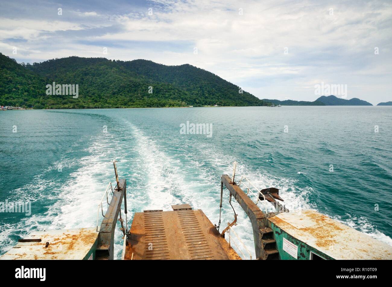 Ferry ramp and trace on the water of tropical sea behind ferry, with ...