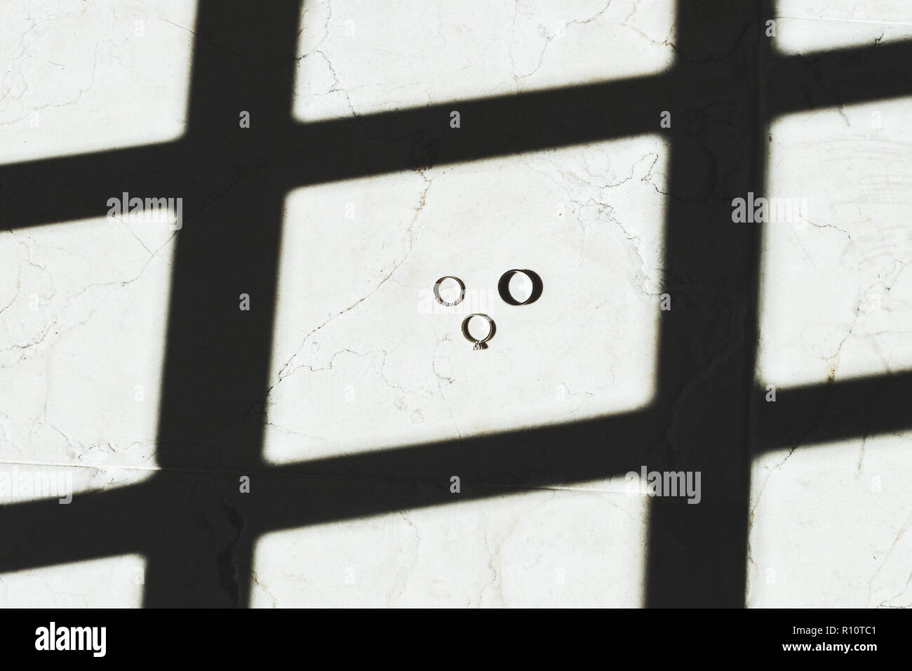 Wedding and engagement rings on white marble Stock Photo - Alamy