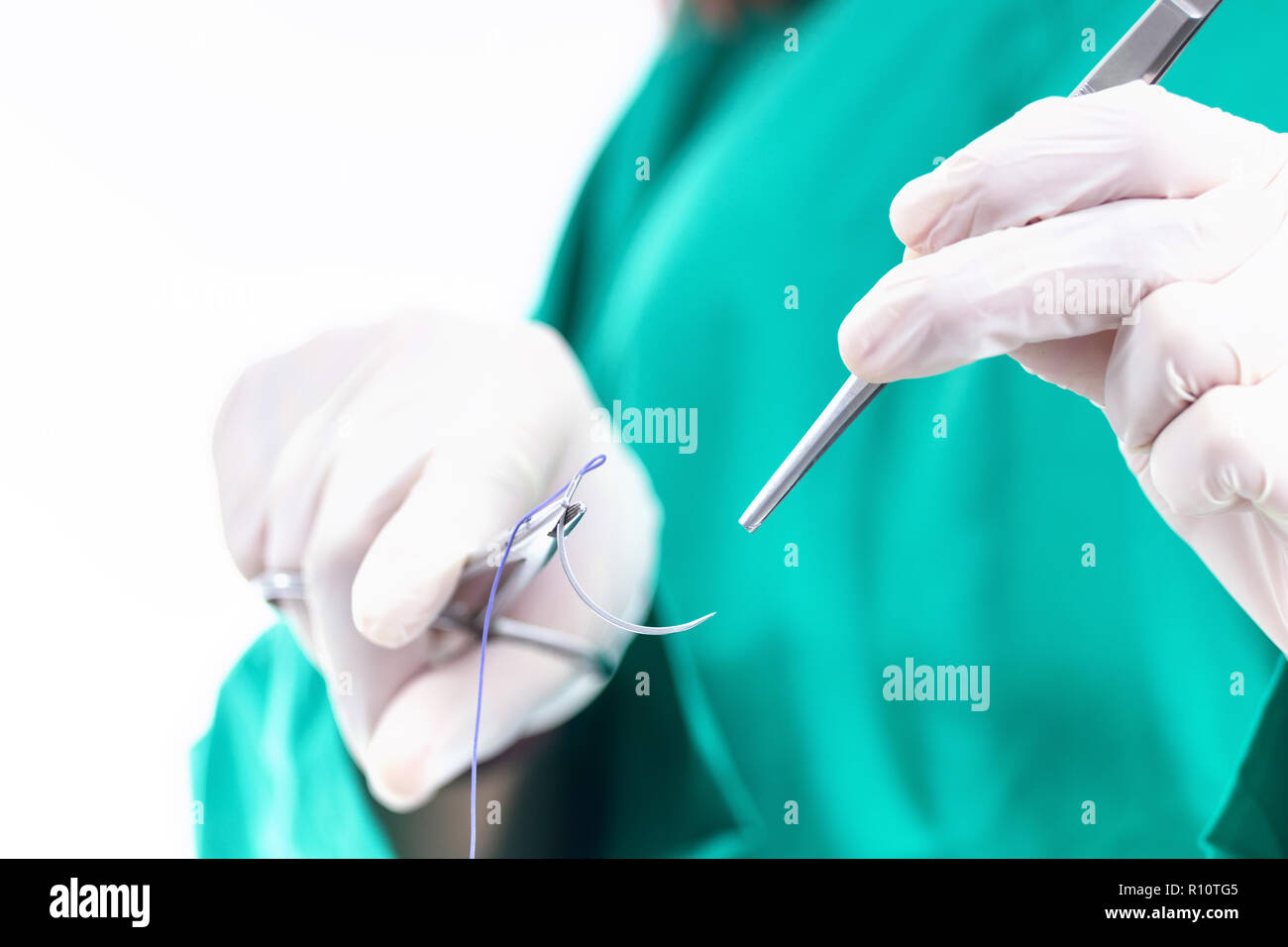 Doctor holding surgical forceps suture needle, suturing material Stock ...